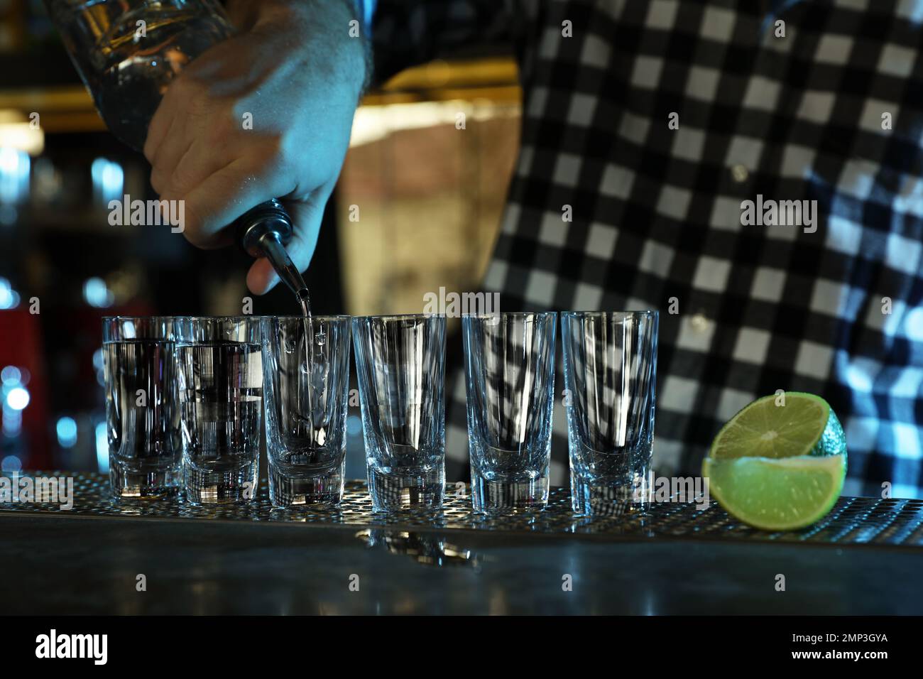 Bartender pouring Mexican Tequila into shot glasses at bar counter, closeup Stock Photo - Alamy