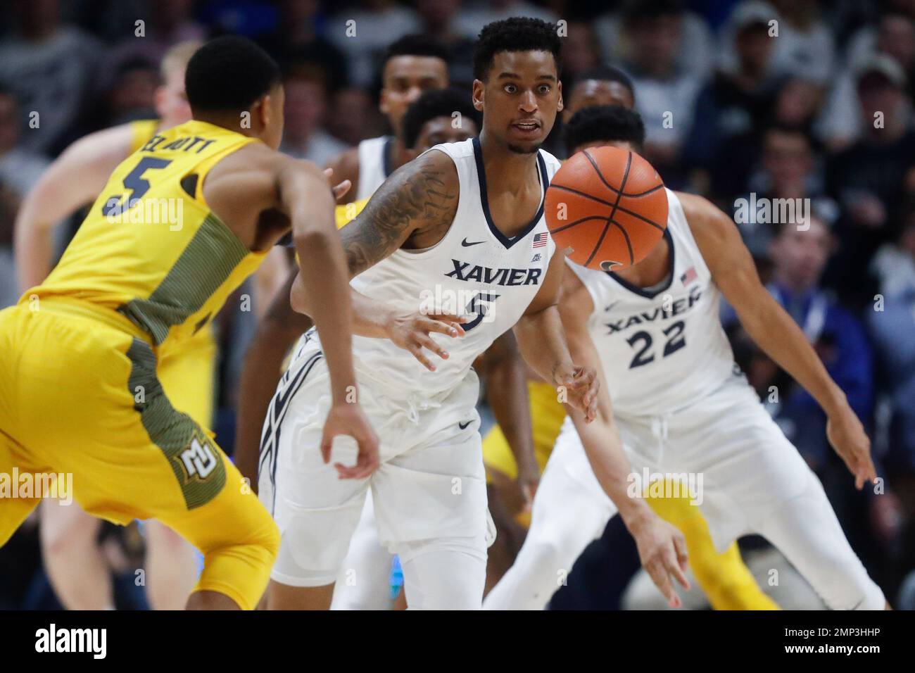 Xavier's Trevon Bluiett, center, eyes a loose ball against Marquette's ...