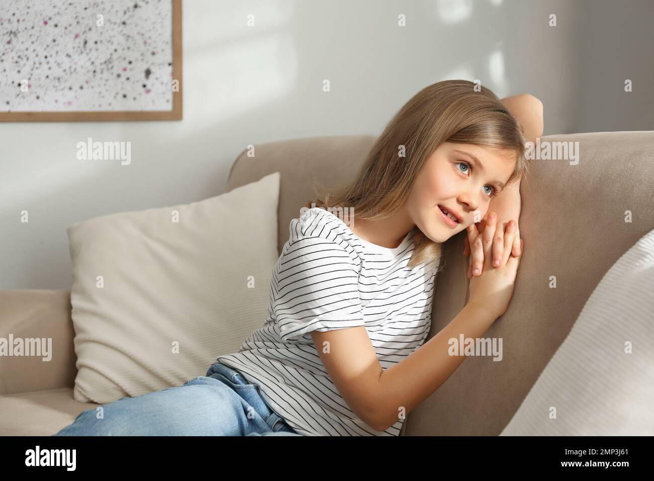 Cute little girl on couch at home Stock Photo - Alamy