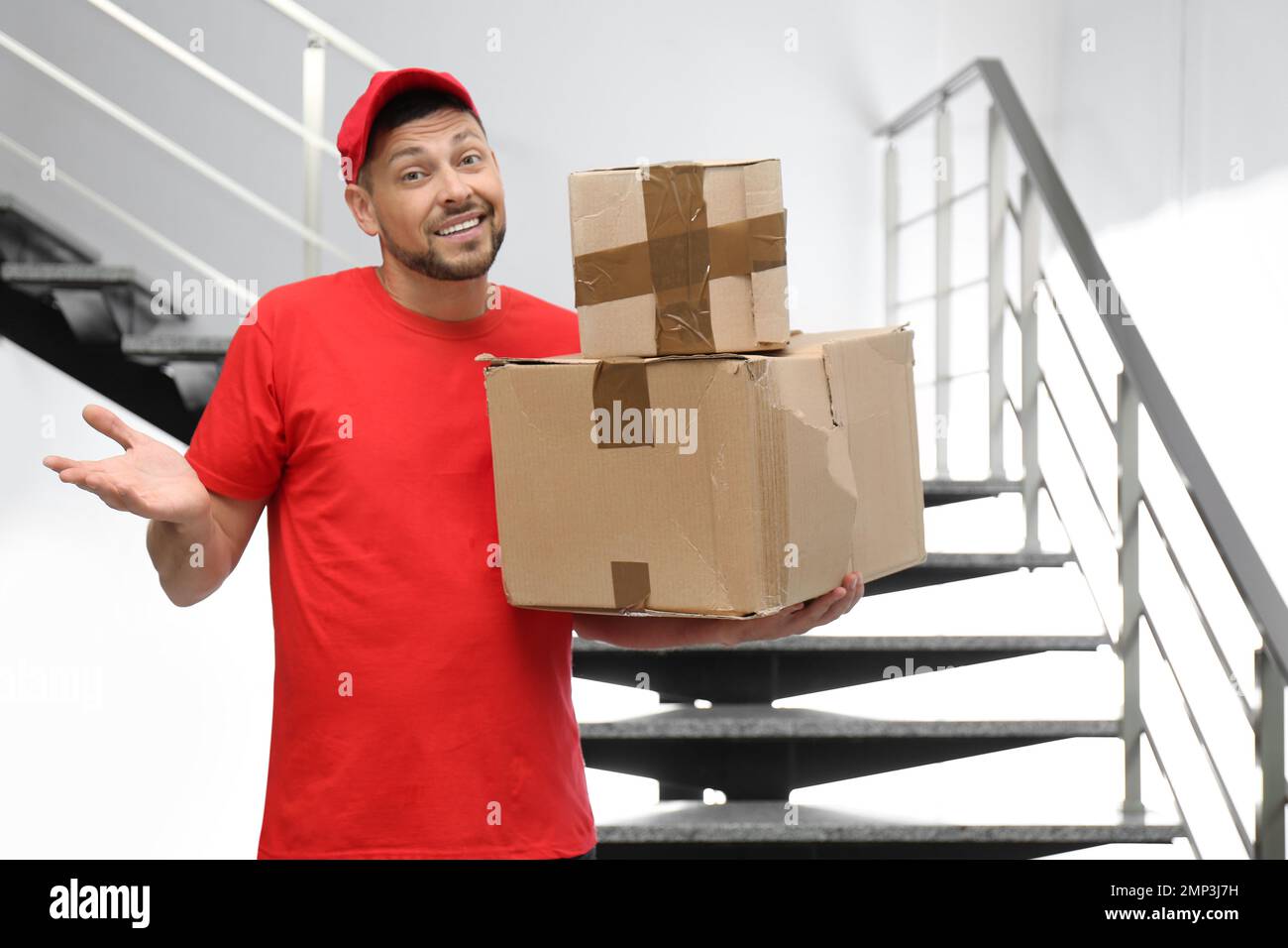 Emotional courier with damaged cardboard boxes indoors. Poor quality ...