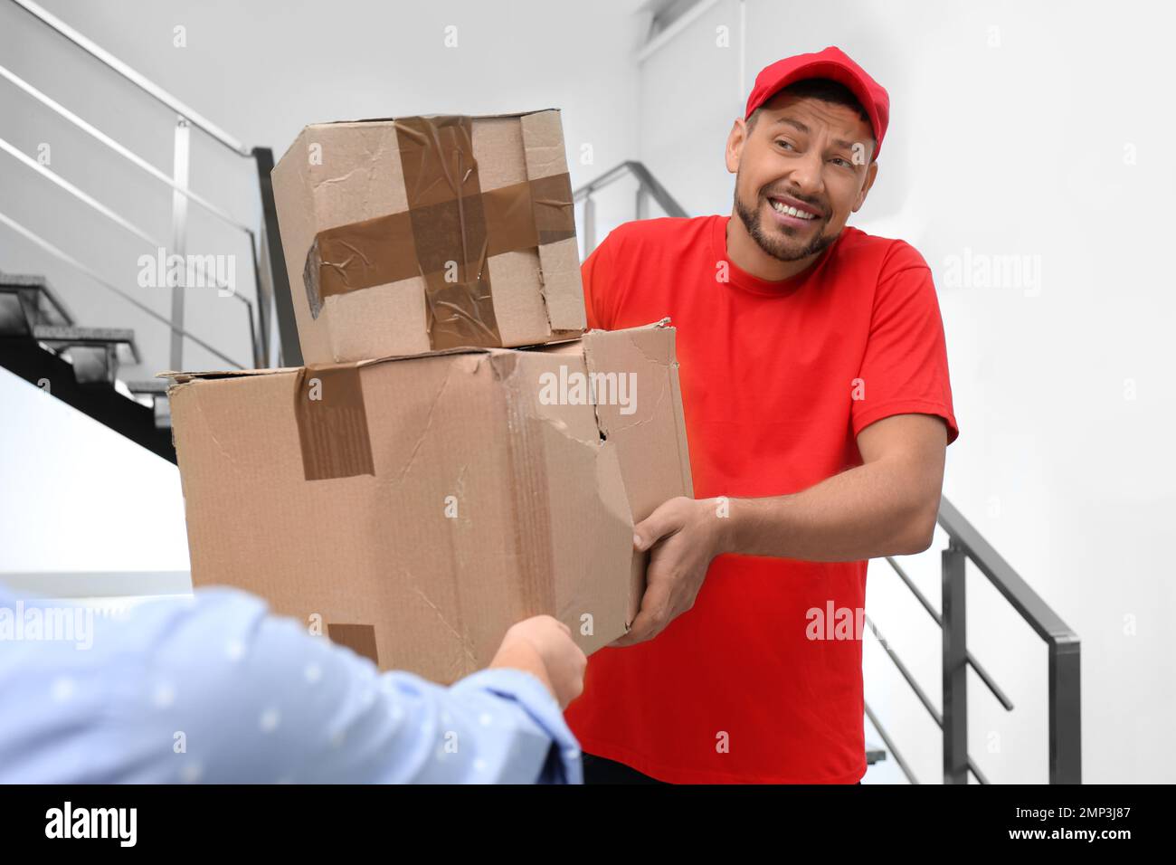 Emotional courier giving damaged cardboard boxes to client indoors ...