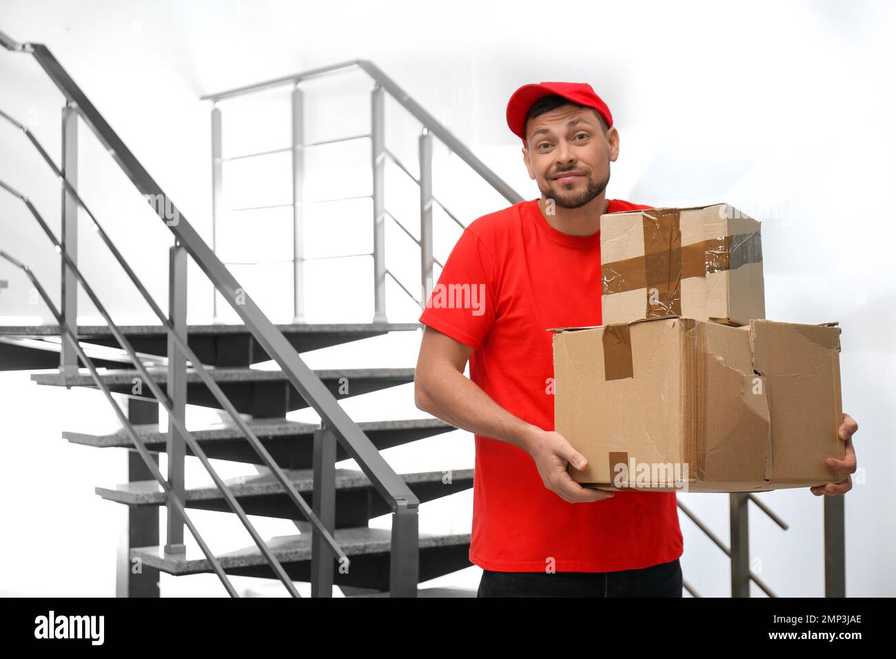 Emotional courier with damaged cardboard boxes indoors. Poor quality ...