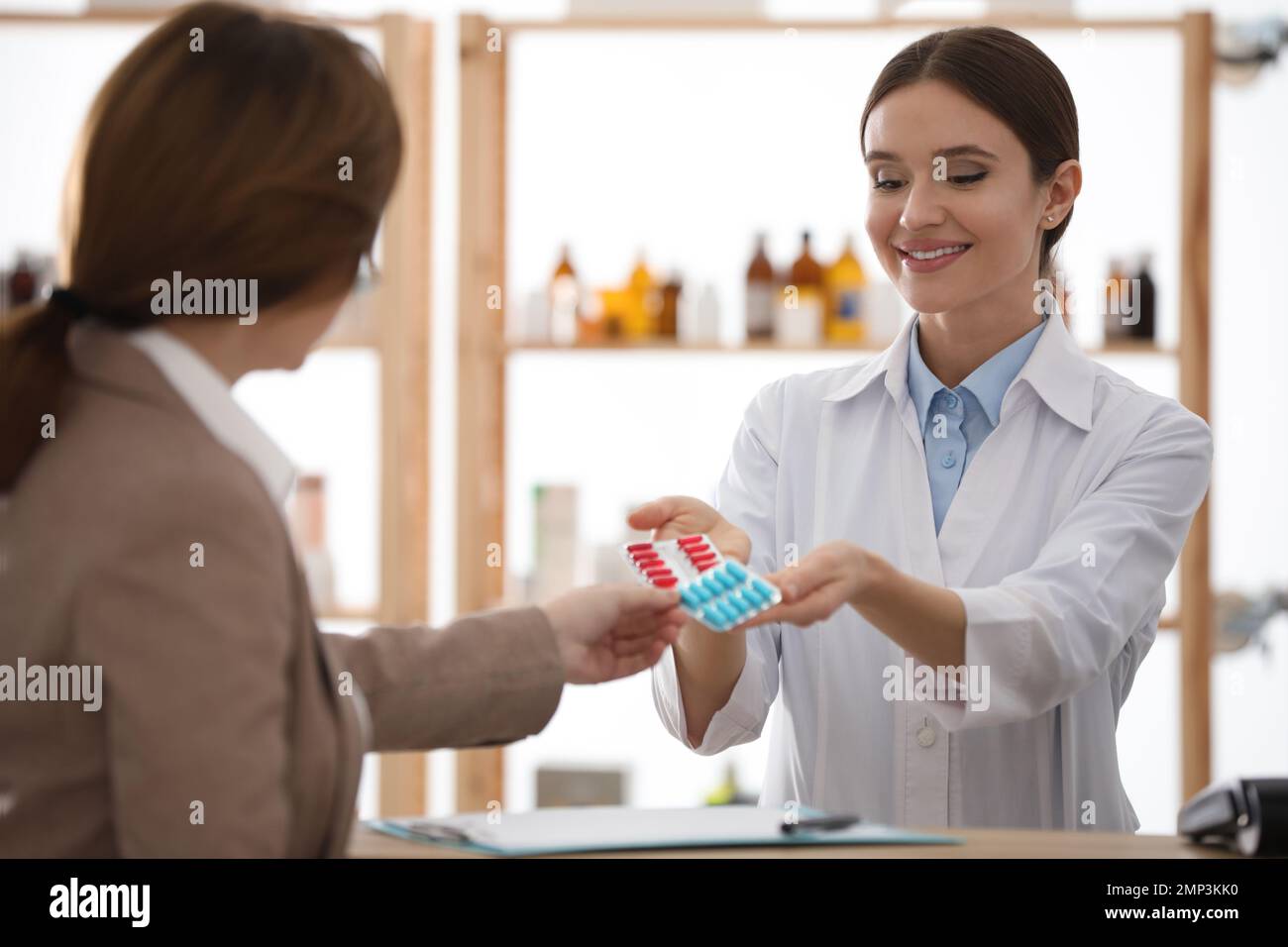 Pharmacist giving medicine to customer in drugstore Stock Photo - Alamy
