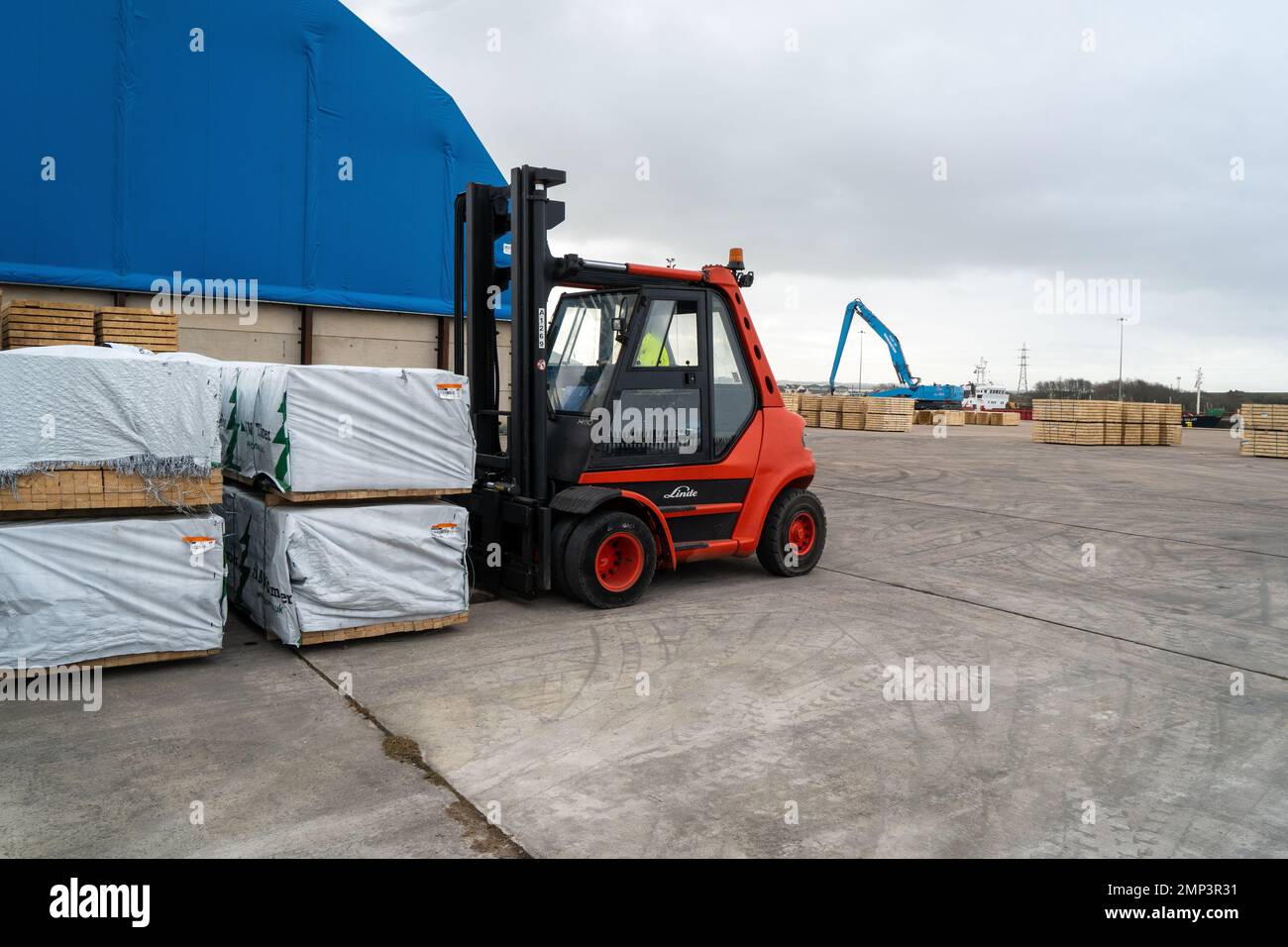 Forklift truck outside picking up pallet of paper Stock Photo - Alamy