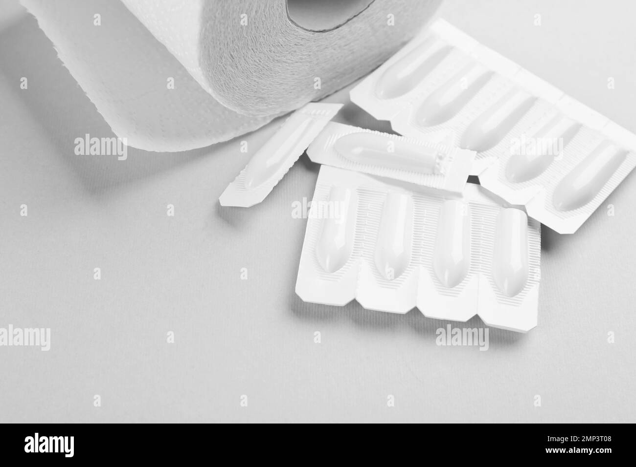Suppositories and toilet paper on light background. Hemorrhoid ...