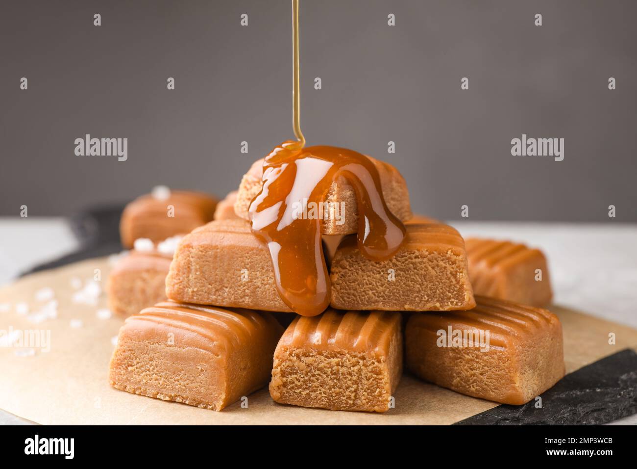 Pouring salted caramel on candies, closeup view Stock Photo - Alamy