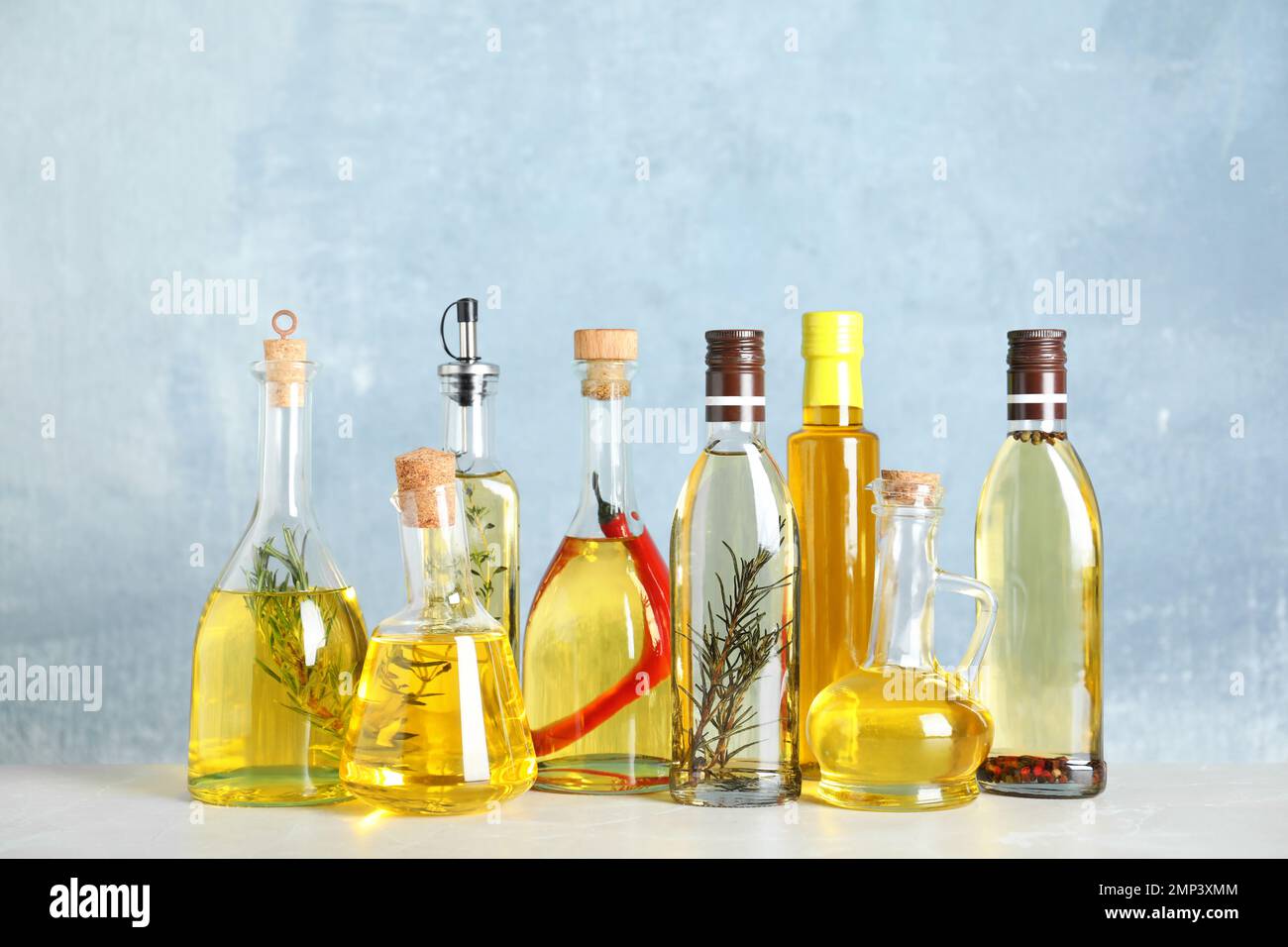 Different sorts of cooking oil in bottles on light grey table Stock ...