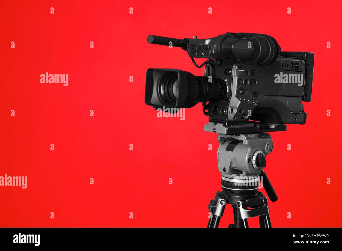 Modern professional video camera on red background Stock Photo - Alamy
