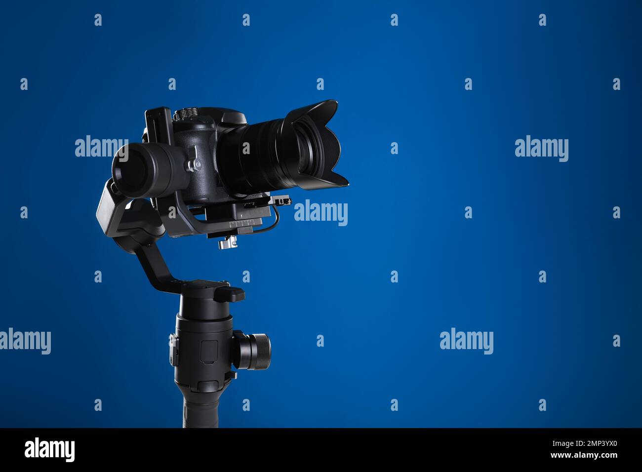 Modern professional video camera on blue background. Space for text ...