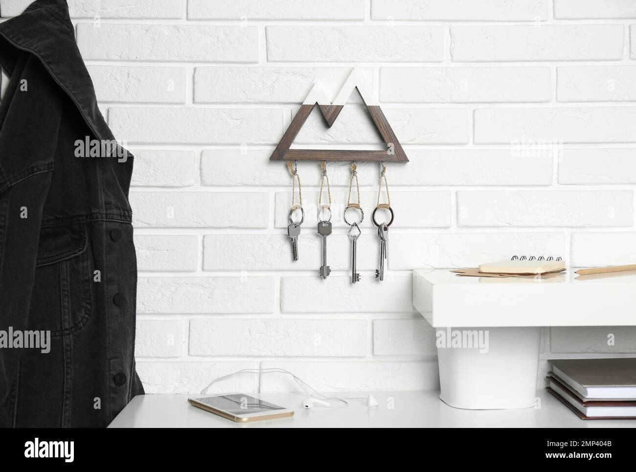 Wooden key holder on white brick wall indoors Stock Photo - Alamy