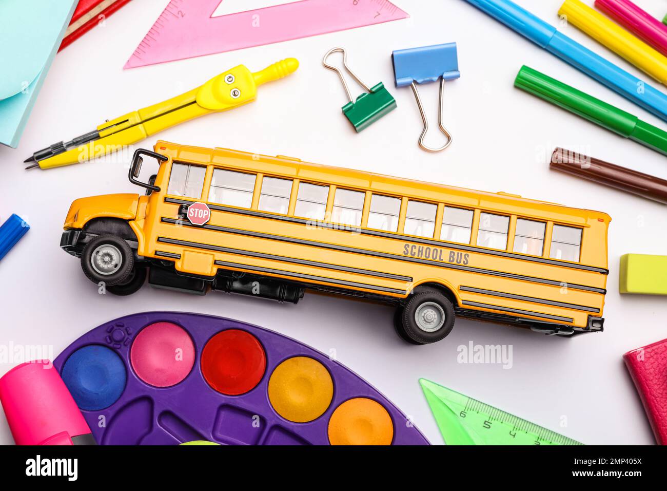 Flat lay composition with yellow school bus model on white background ...