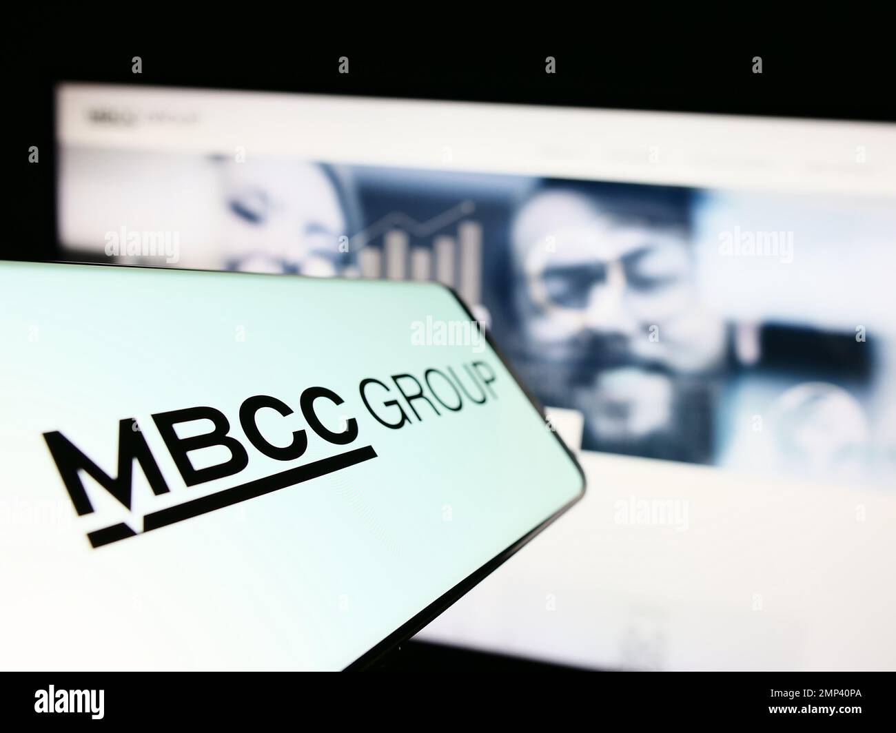Mobile phone with logo of German construction chemicals company MBCC Group on screen in front of ...