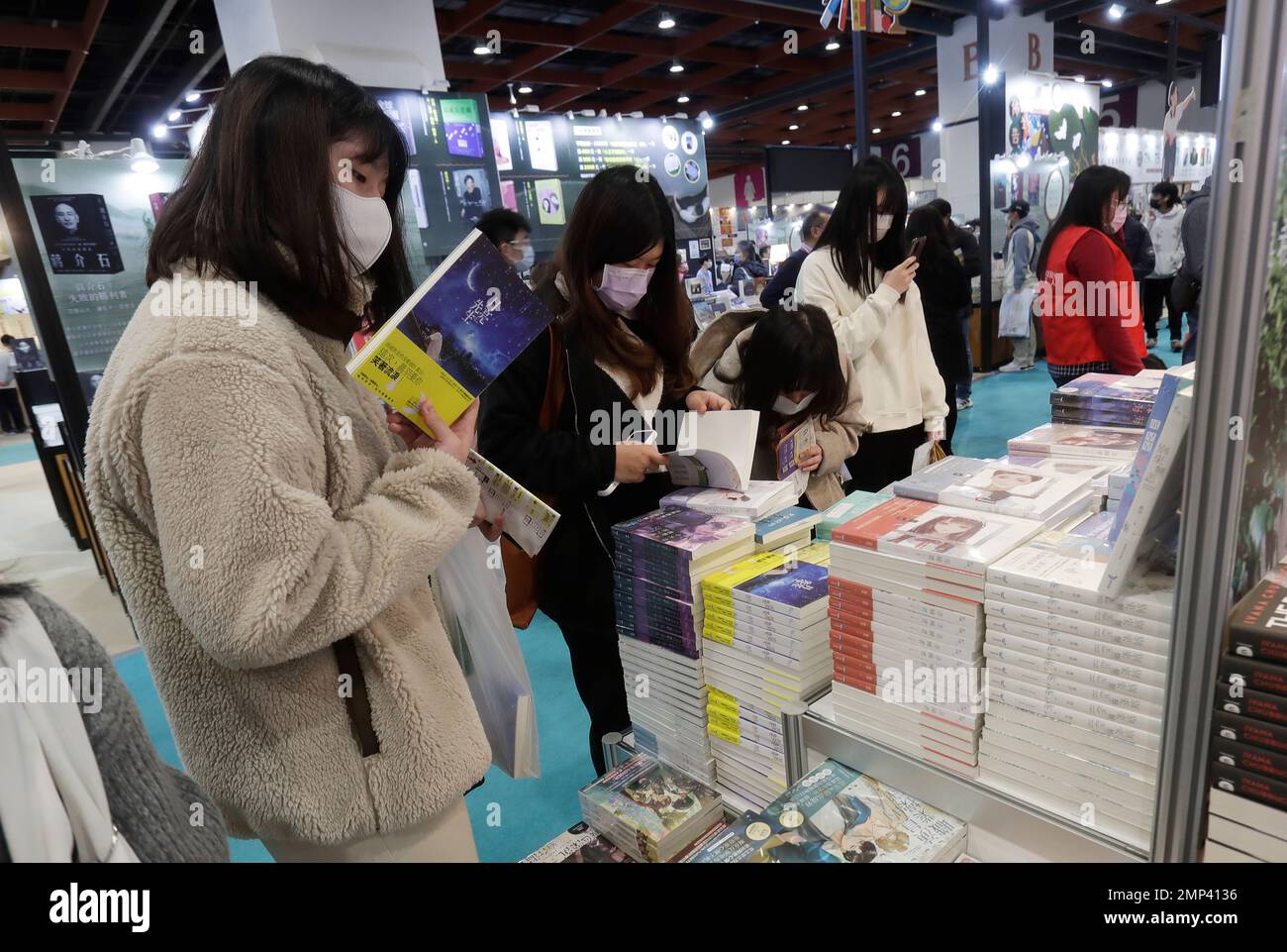 People gather around tables with newly released books on display during ...