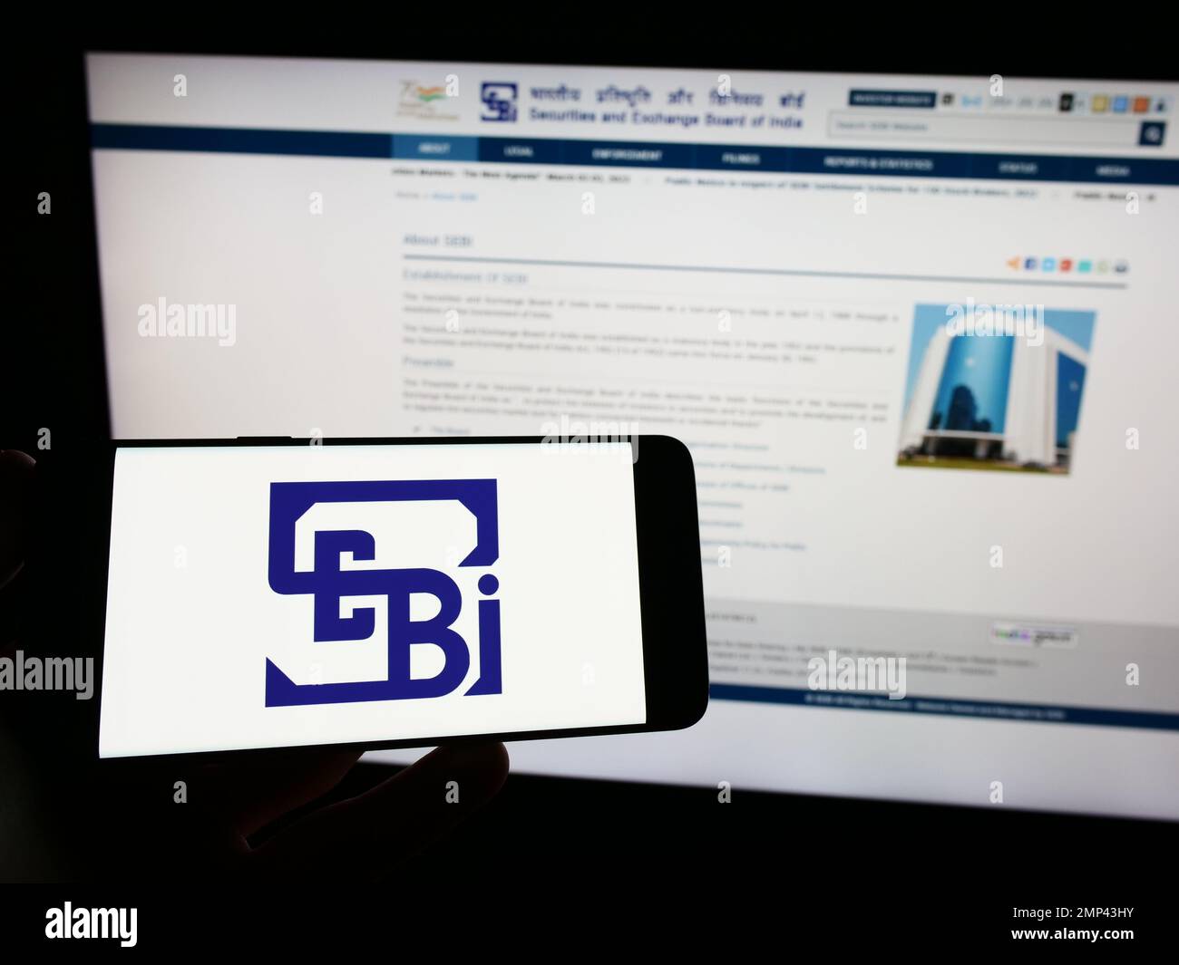 Person holding smartphone with logo of Securities and Exchange Board of ...
