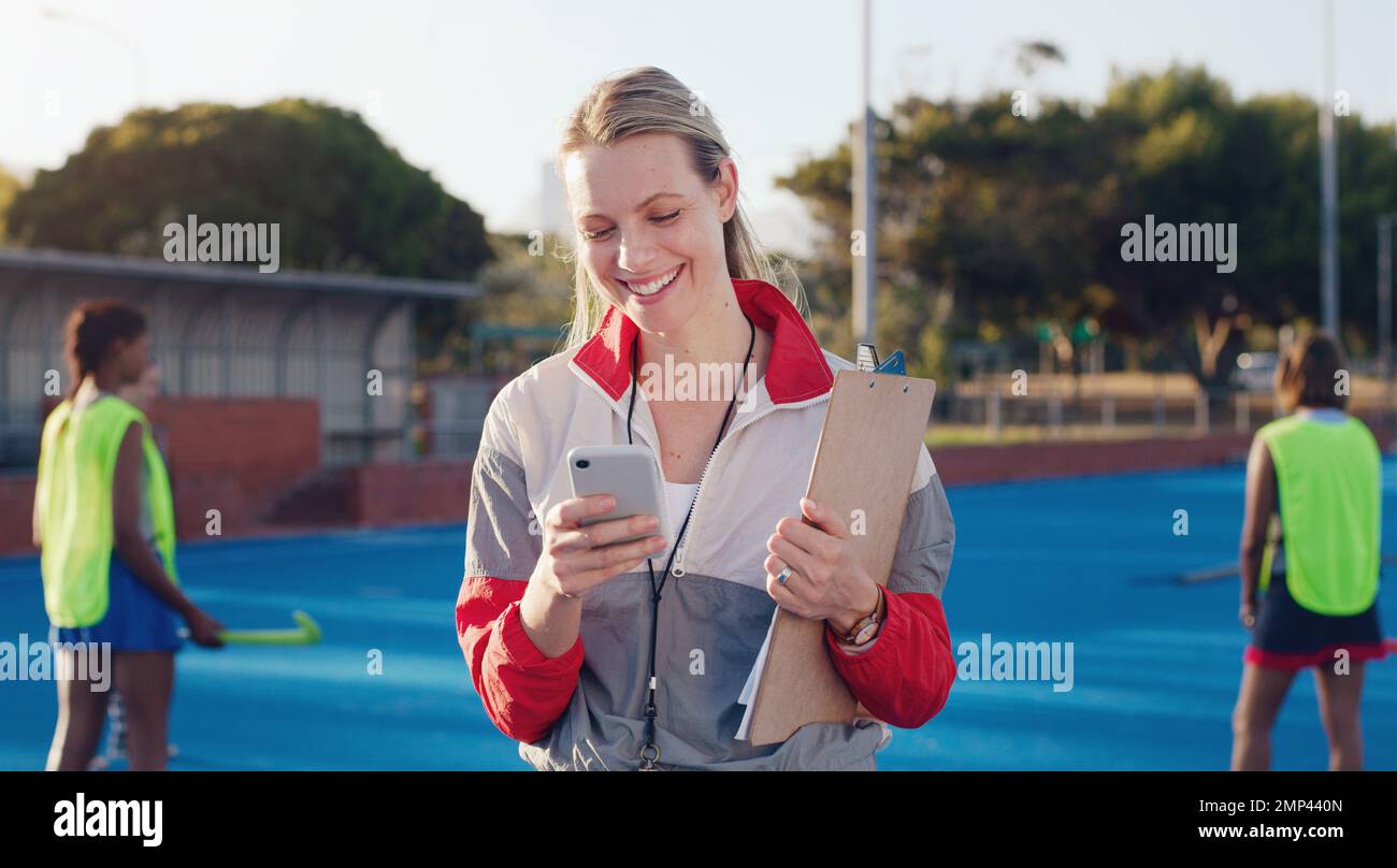 Hockey, coach and woman with phone at group training at a stadium for ...