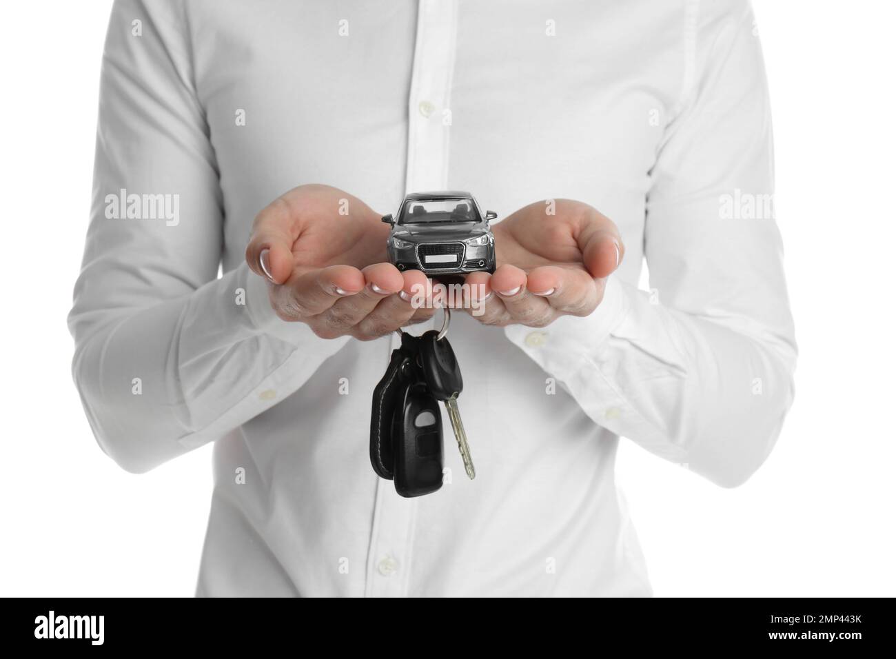 Man holding key and miniature automobile model on white background ...