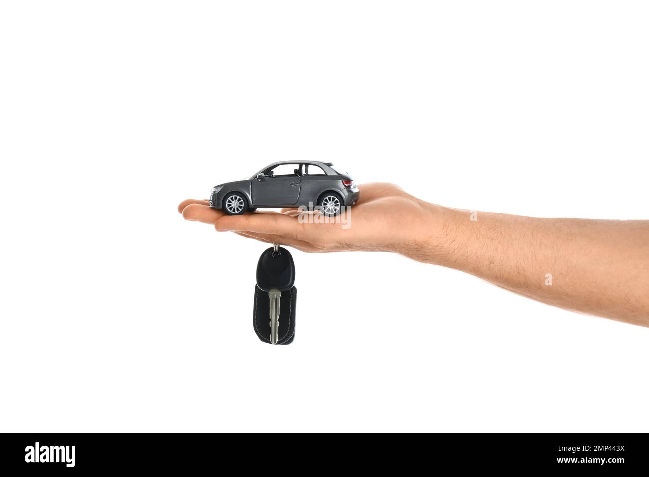 Man holding key and miniature automobile model on white background ...