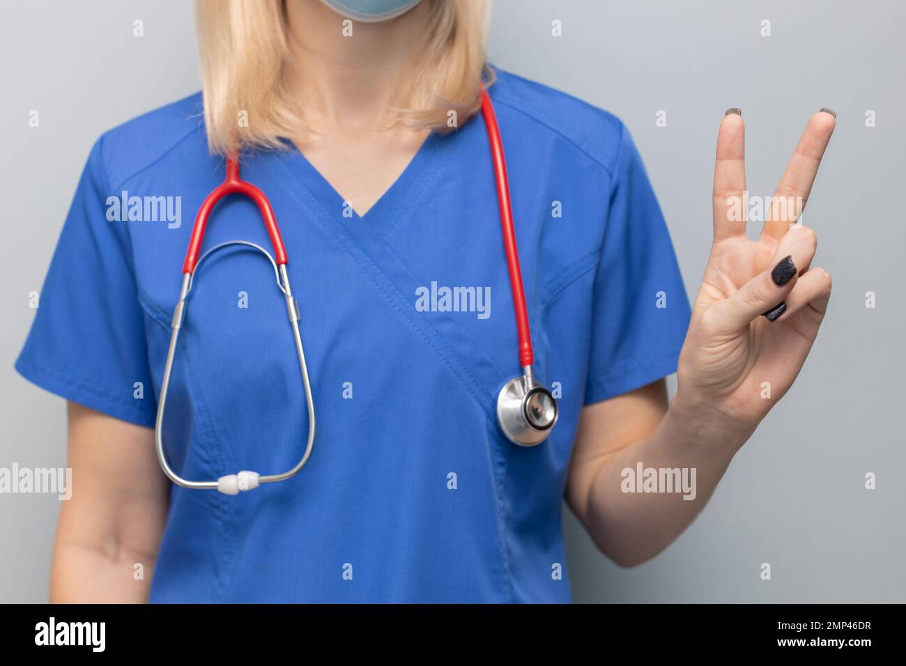 the doctor in the hospital shows a gesture denoting victory. doctor ...