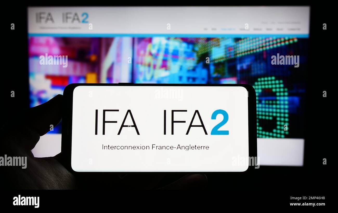 Person holding mobile phone with logo of Interconnexion France ...