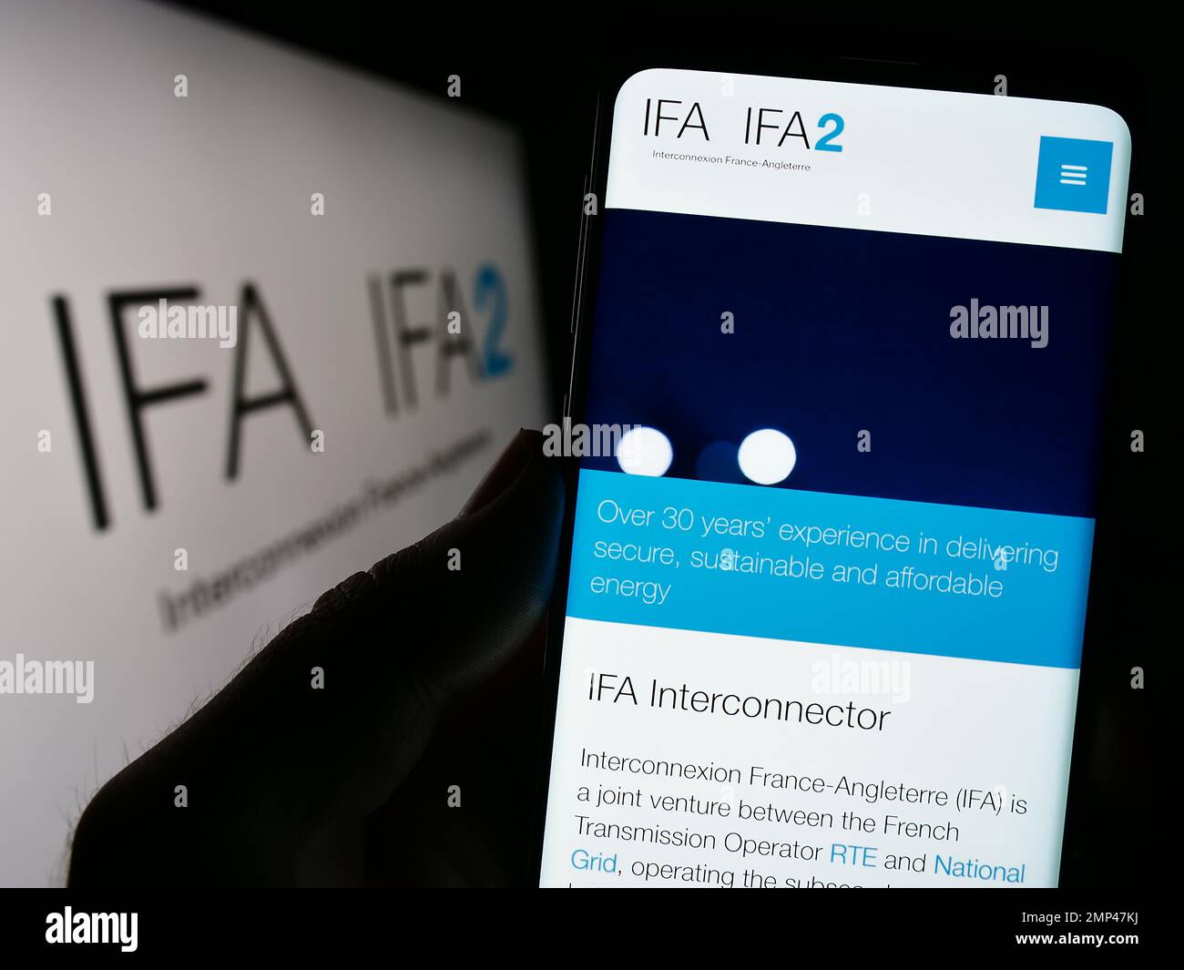 Person holding smartphone with webpage of Interconnexion France ...