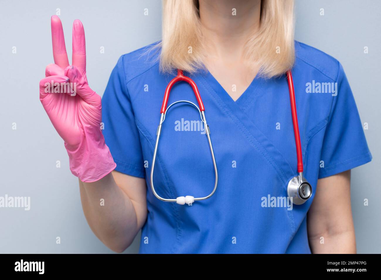 the doctor in the hospital shows a gesture denoting victory. doctor ...