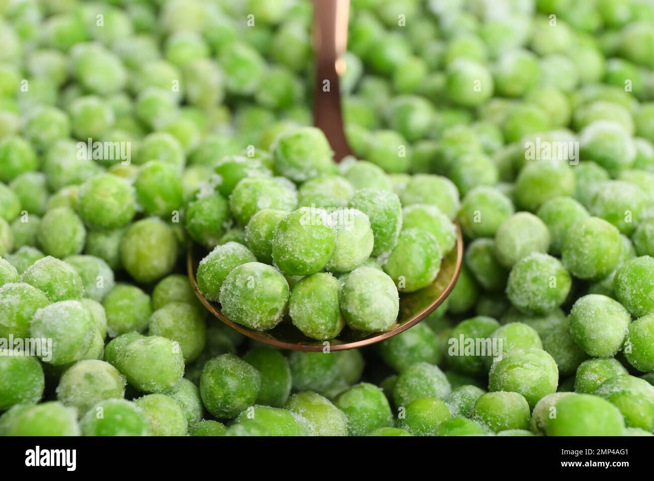 Frozen peas and spoon, closeup. Vegetable preservation Stock Photo - Alamy