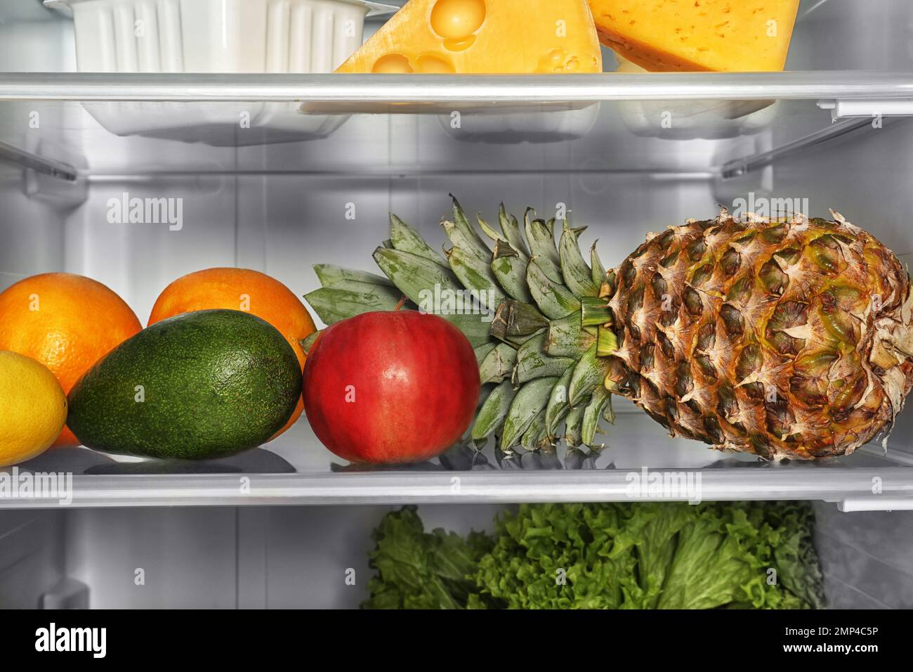 Different fresh fruits on shelf in refrigerator Stock Photo - Alamy