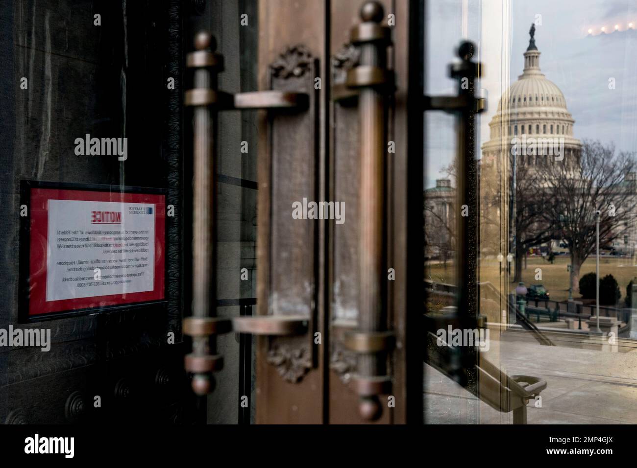 The dome of the Capitol Building is visible in reflection next to a ...