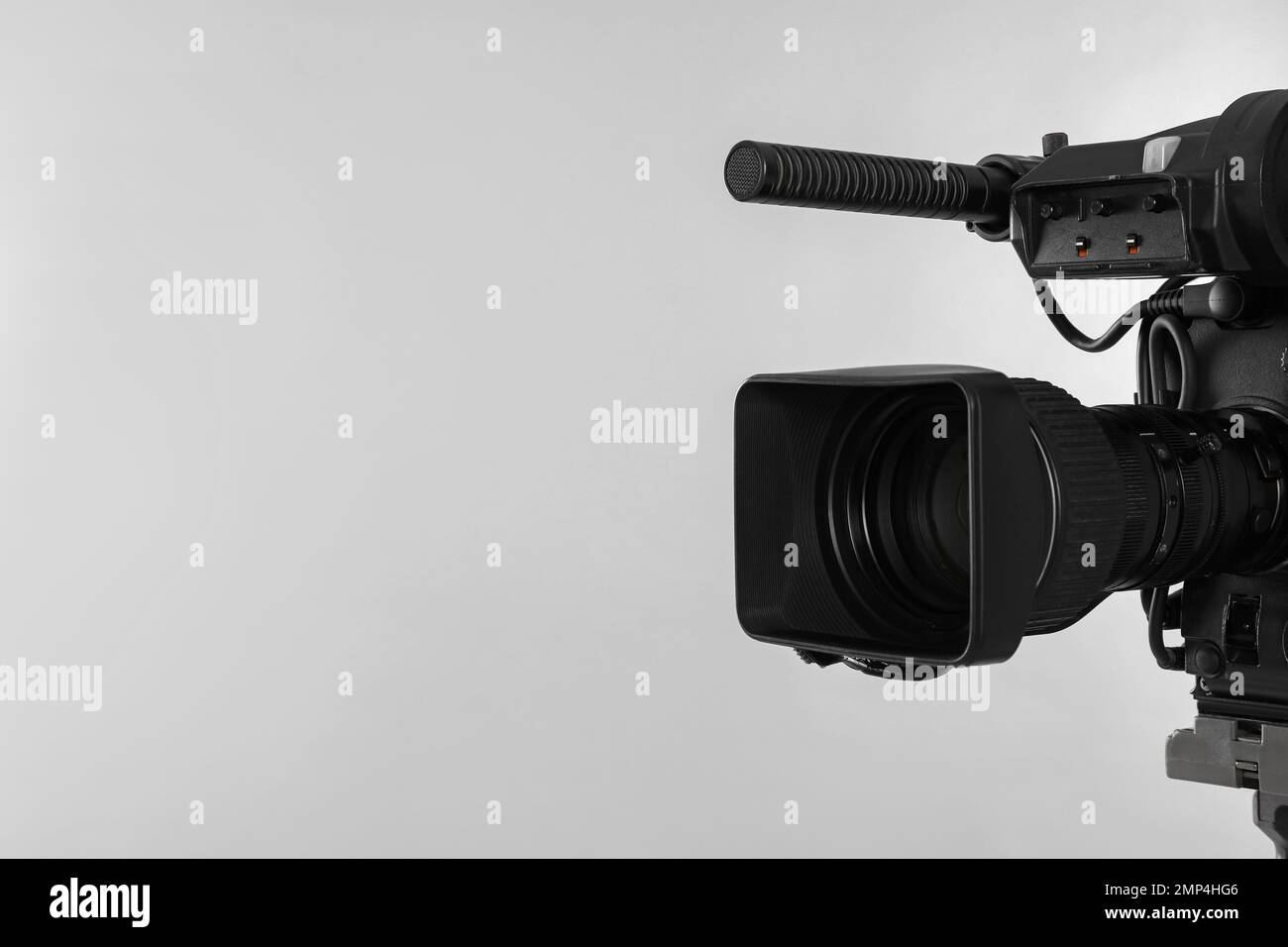 Modern professional video camera on light background. Space for text ...