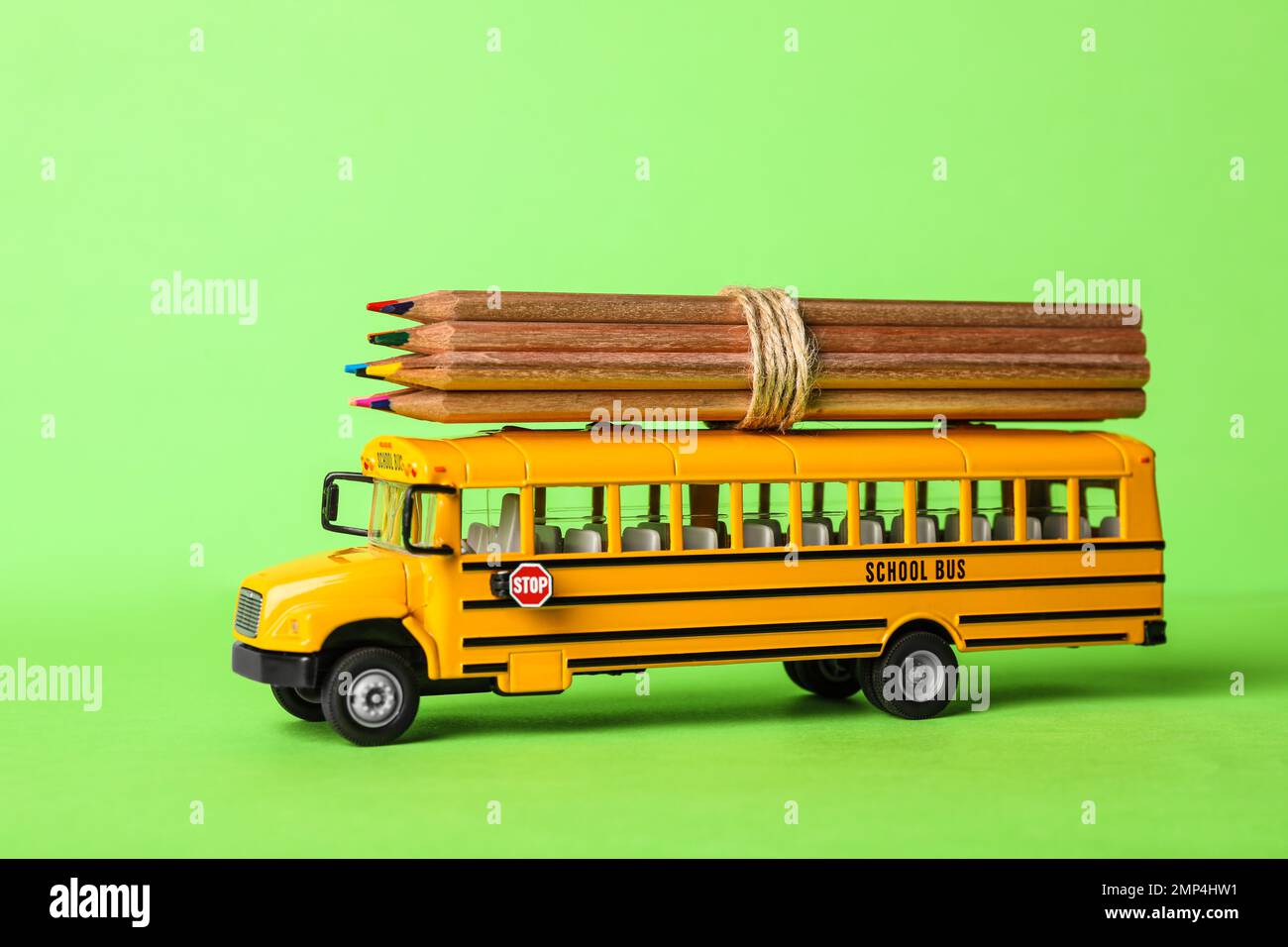 School bus model with color pencils on green background. Transport for ...