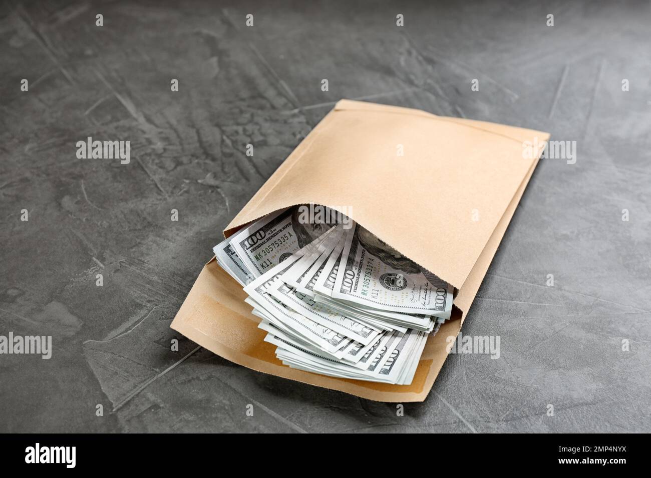 Envelope with dollar bills on grey stone table. Bribe concept Stock ...