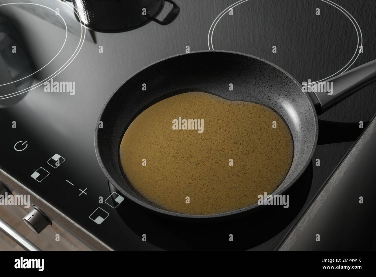 Frying pan with cooking oil on induction stove Stock Photo - Alamy