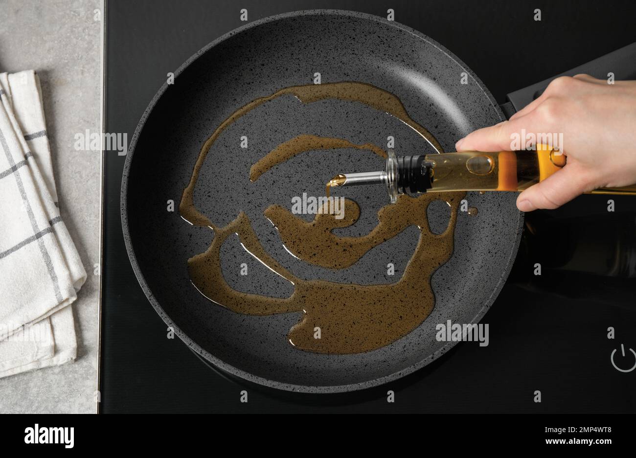 Woman pouring cooking oil from bottle into frying pan, top view Stock ...