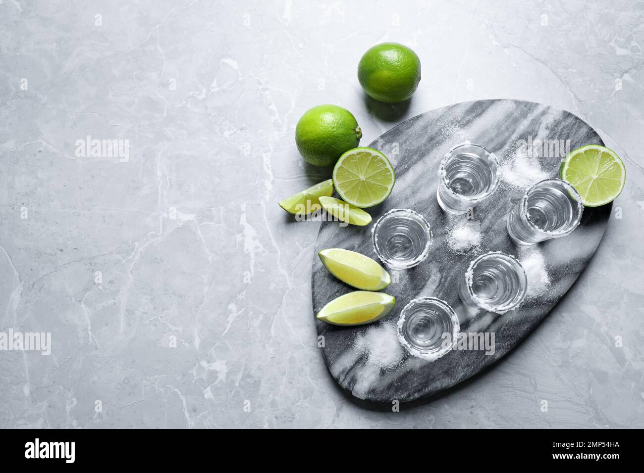 Mexican Tequila shots, lime slices and salt on grey marble table, flat ...