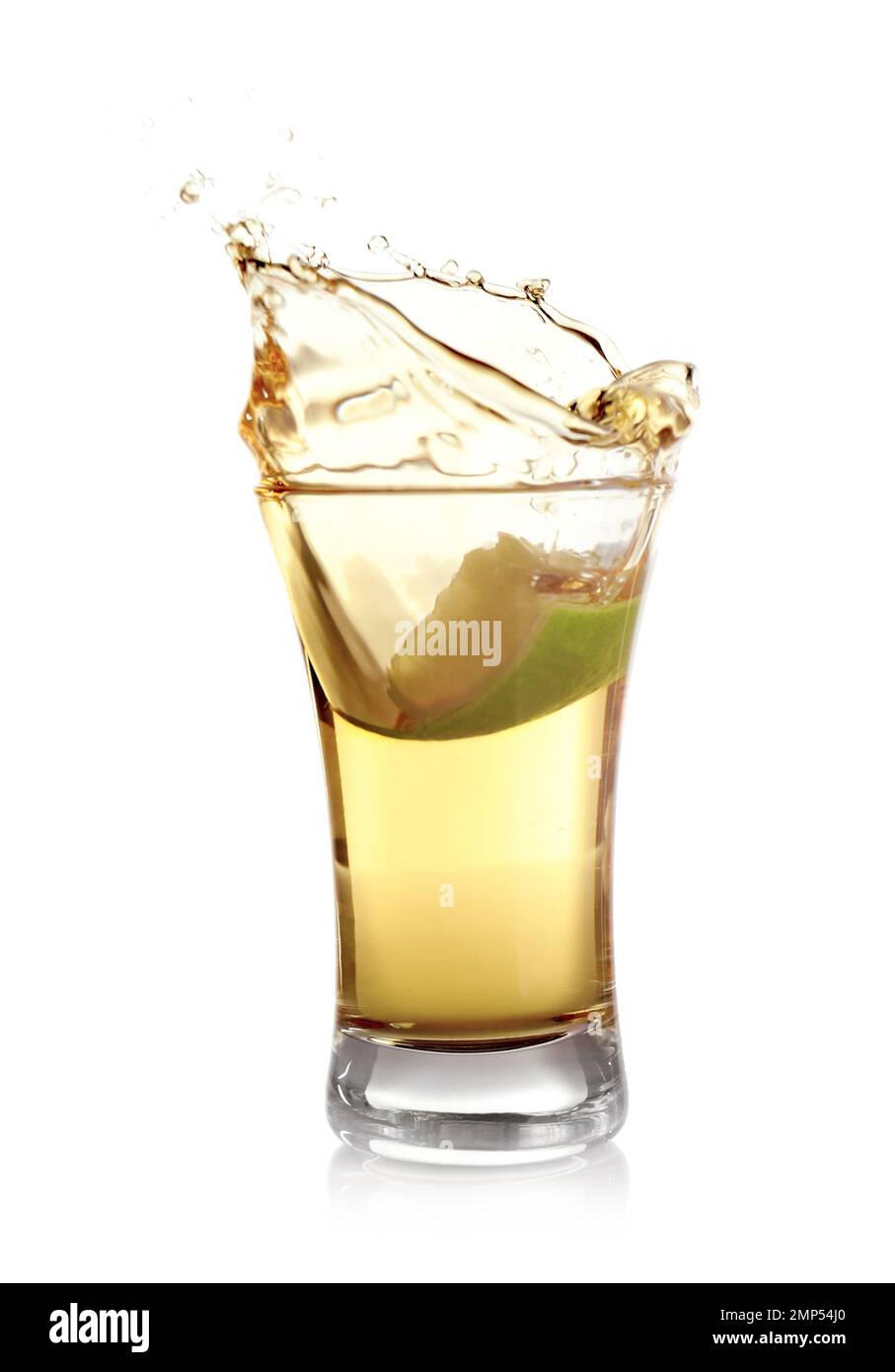 Splashing Mexican Tequila in shot glass with lime slice isolated on ...