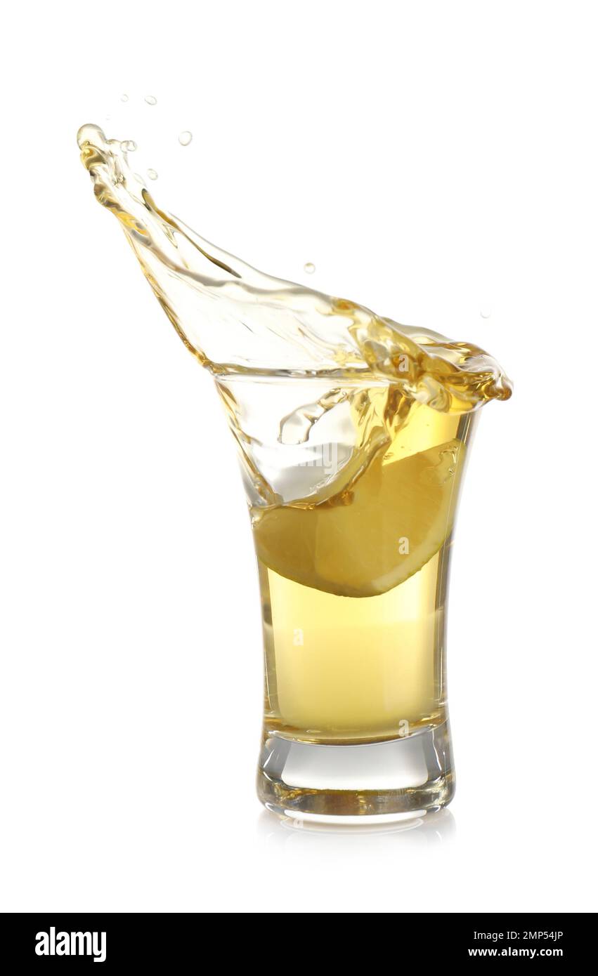 Splashing Mexican Tequila in shot glass with lime slice isolated on ...