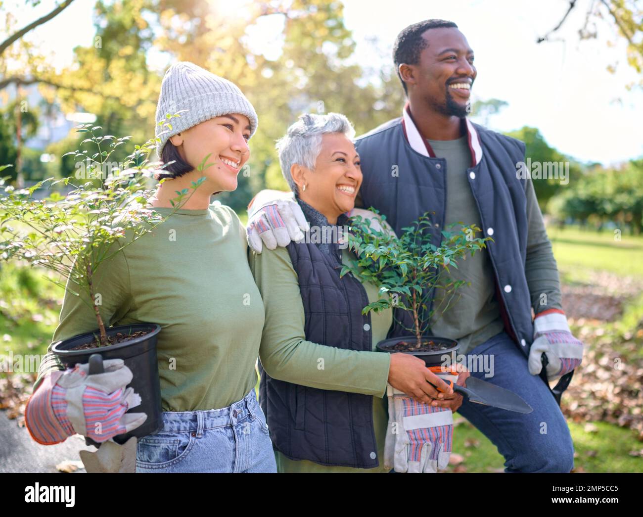 Volunteer group, plants and gardening in a park with trees in nature ...