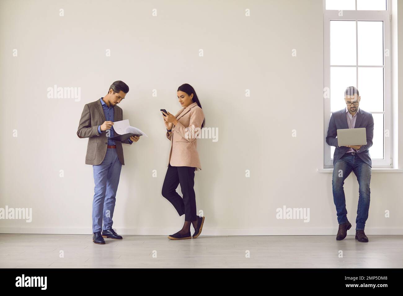 Full-size photo of partners standing near wall in spacious bright room ...