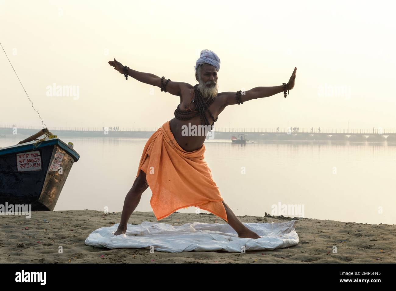 Rome Baba Sadhu practising yoga at sunrise on Ganges riverbank, For ...