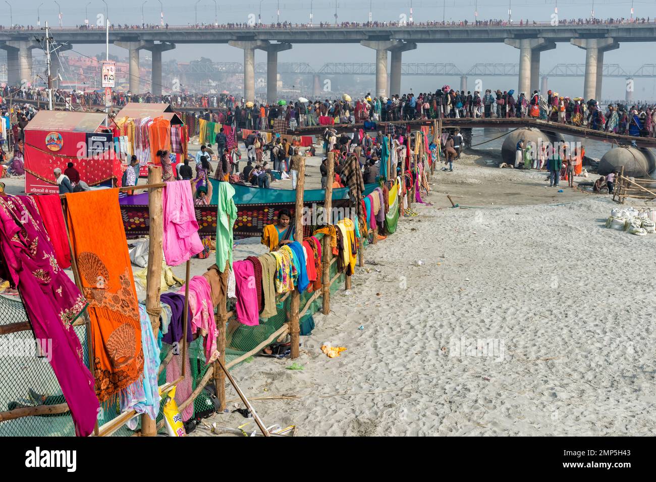 Pilgrims crossing the Ganges river on a temporary pontoon bridge ...