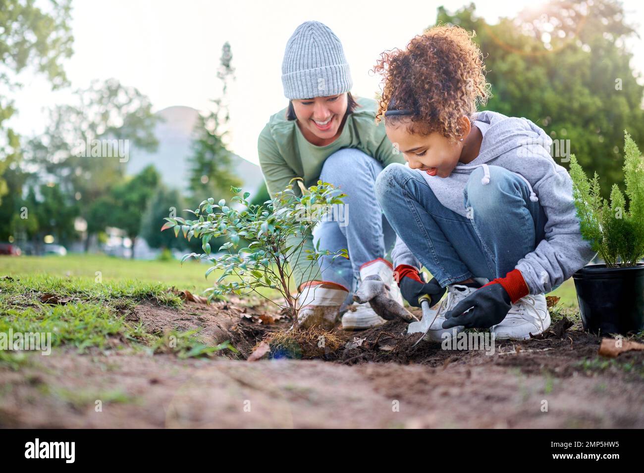Volunteer, child and woman with plant for gardening in park with trees ...