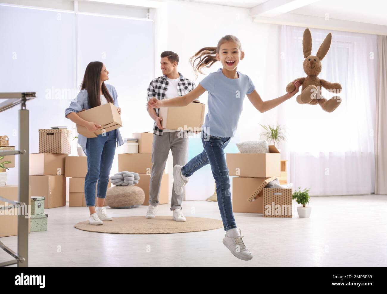 Happy family in room with cardboard boxes on moving day Stock Photo - Alamy