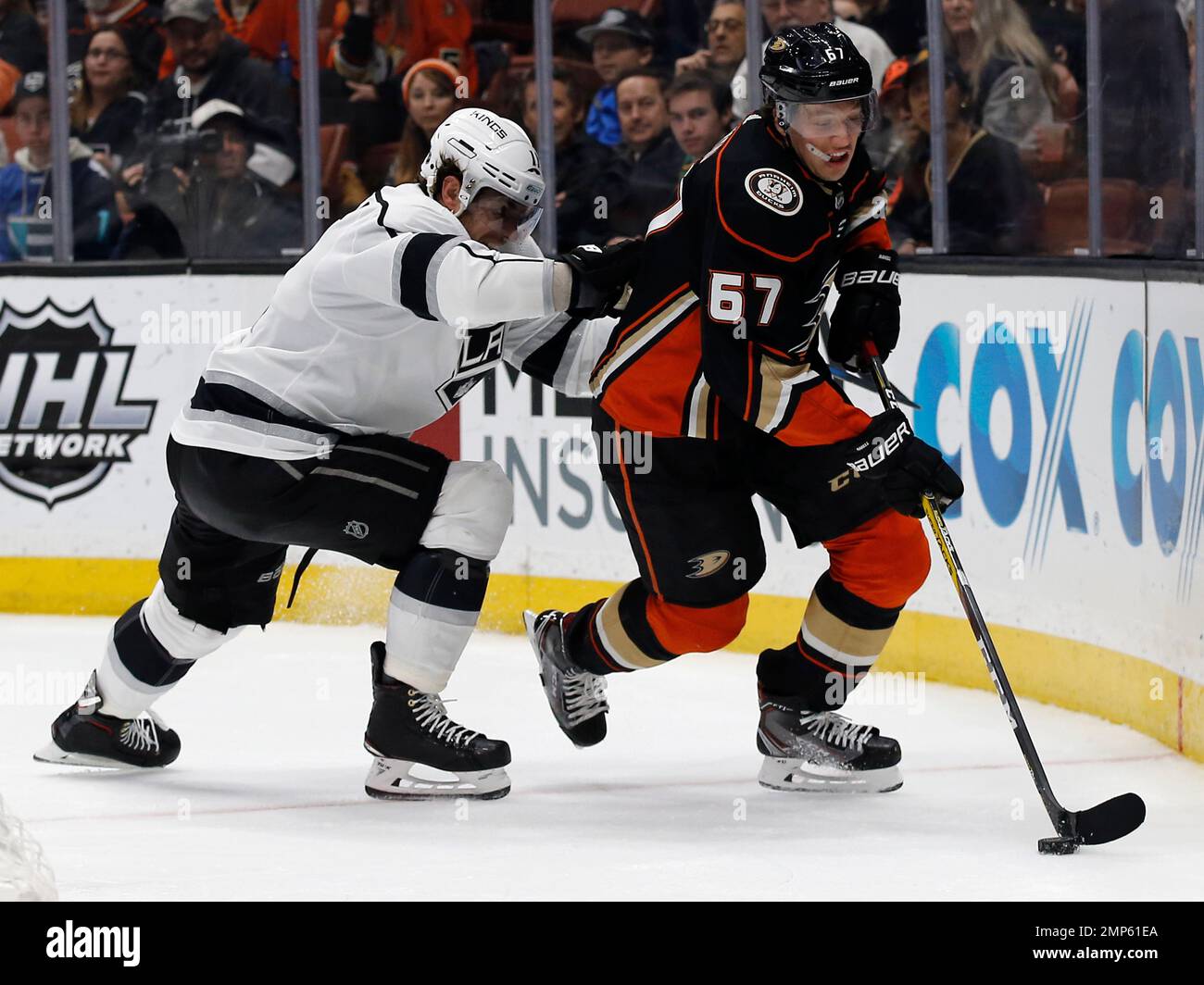 Los Angeles Kings center Anze Kopitar, left, of Slovenia, checks Anaheim Ducks center Rickard ...