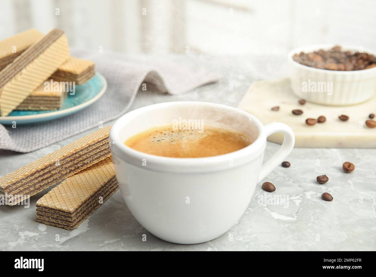 Delicious wafers and cup of coffee for breakfast on grey marble table ...