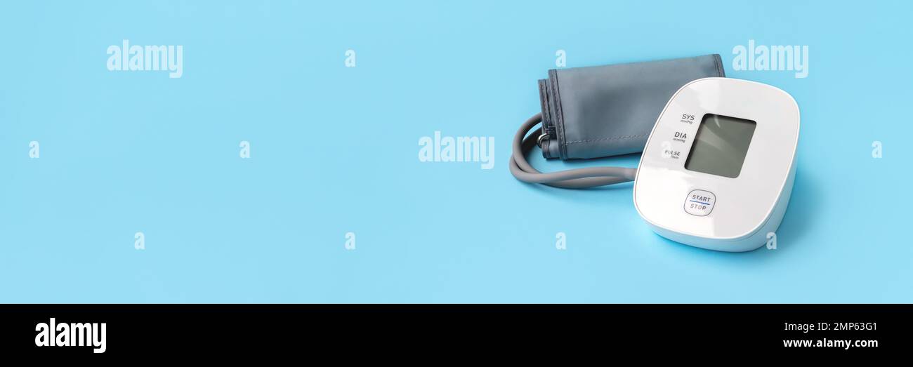 Automatic blood pressure monitor on blue background banner. Medical ...