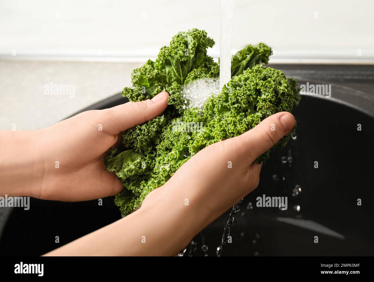 Woman washing fresh kale leaves over sink, closeup Stock Photo - Alamy