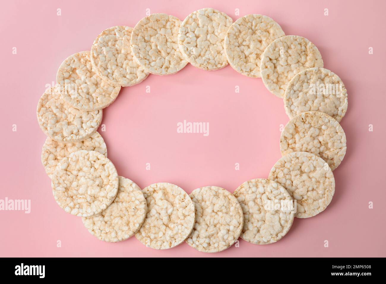 Frame made of puffed rice cakes on pink background, flat lay. Space for ...