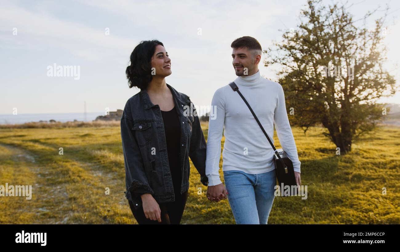 boyfriends walking hand in hand in a field Stock Photo - Alamy