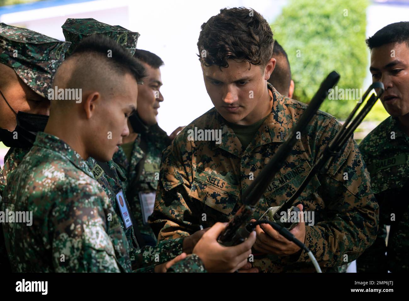 U.S. Marine Corps Cpl. Brandon Sells (center), a radio operator with 3d Marine Division ...