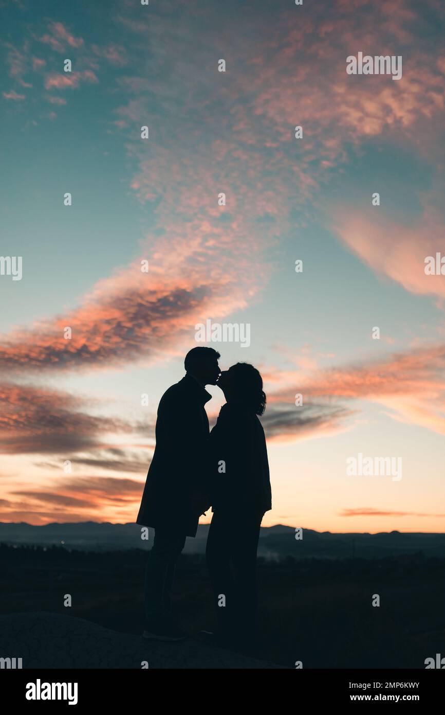 Couple kissing under stunning sunset sky Stock Photo - Alamy